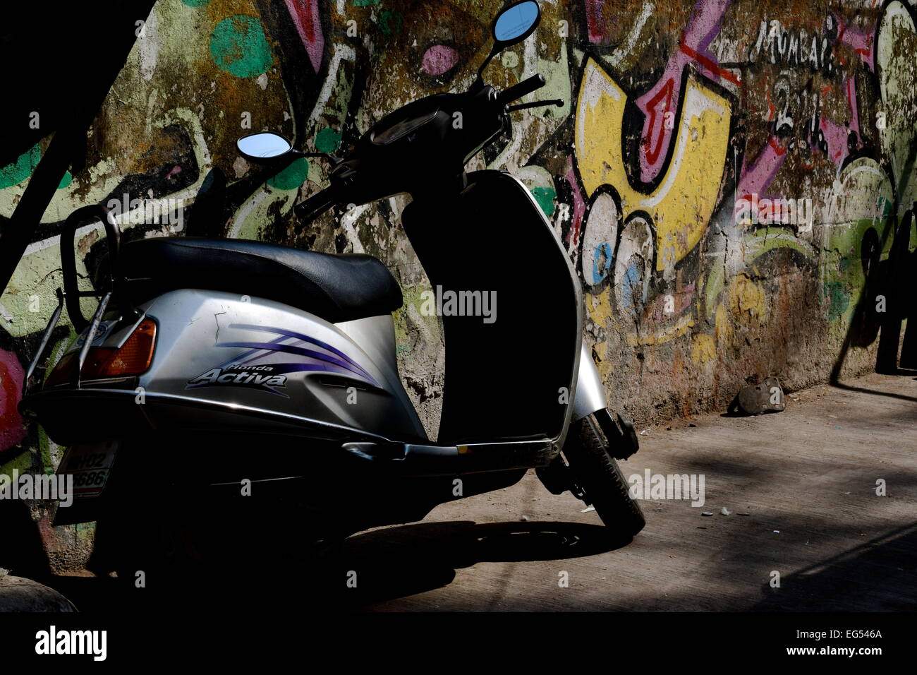 Motor scooter against wall with graffiti Stock Photo - Alamy