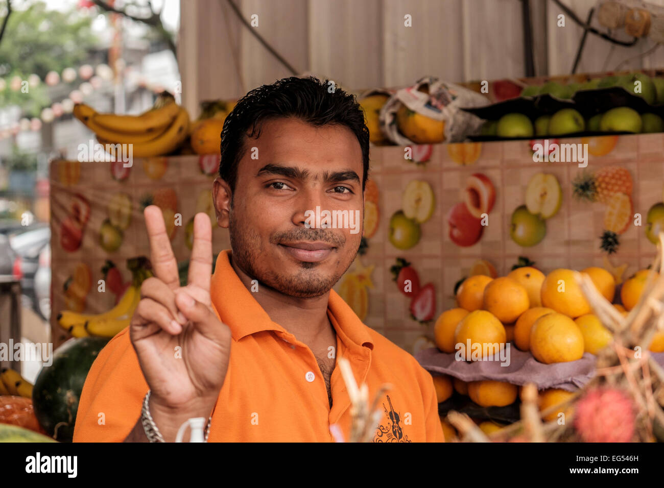 Stall holder at a fruit and veg stand in the street in Kuala Lumpur ...