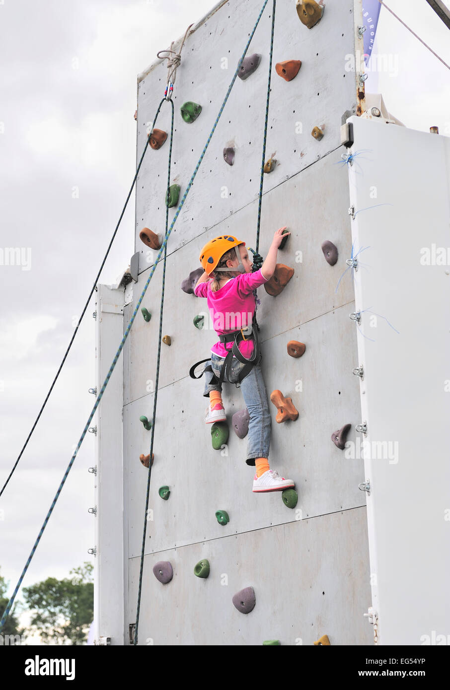 Young girl with safety harness climbing a wall Stock Photo - Alamy