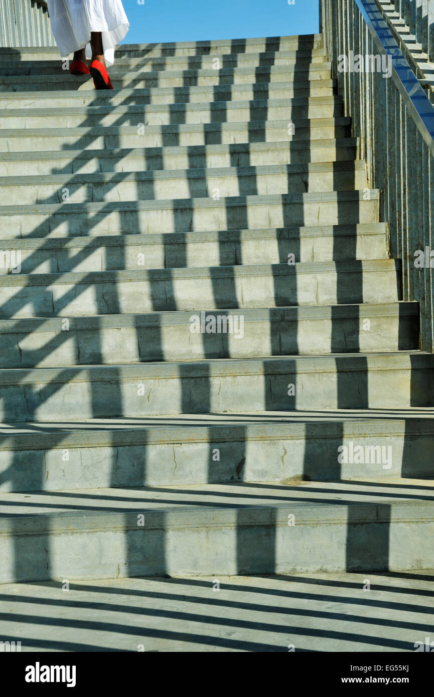 Red shoes of single adult woman climbing up concrete stairs with ...