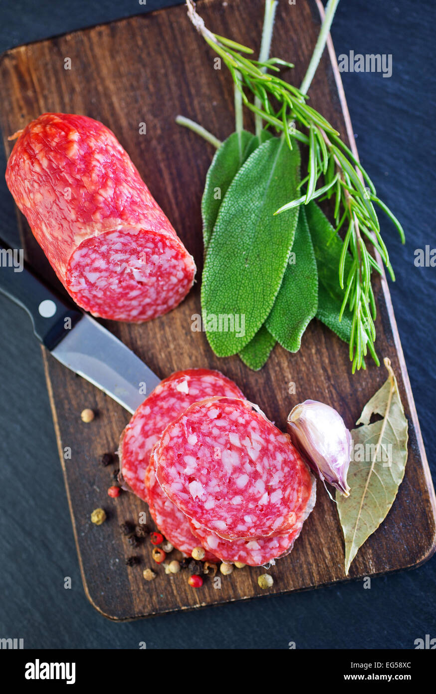 salami and knife, salami on black table Stock Photo - Alamy
