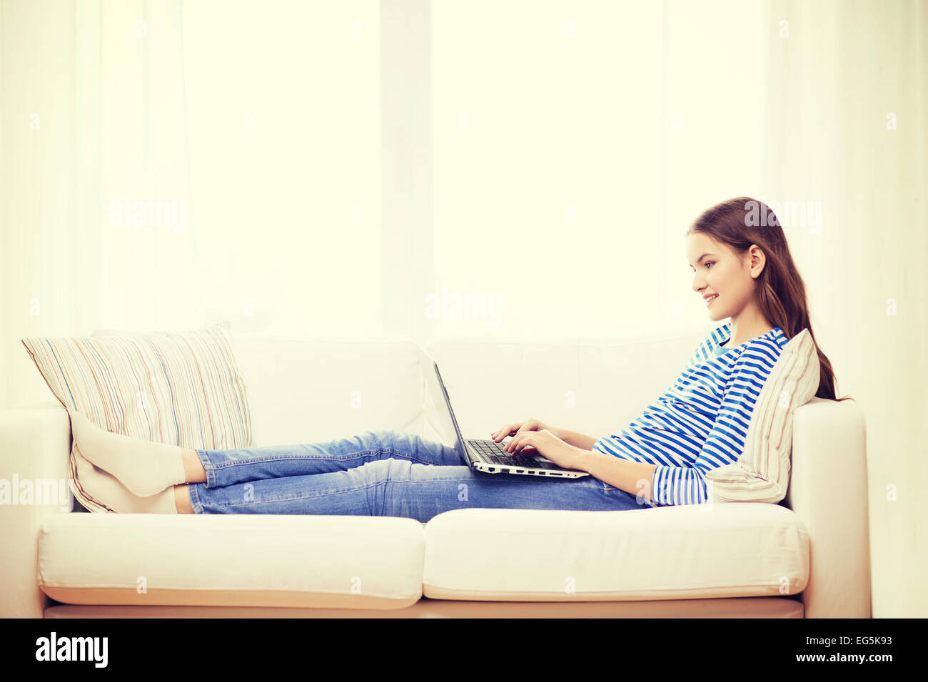 smiling teenage girl with laptop computer at home Stock Photo - Alamy