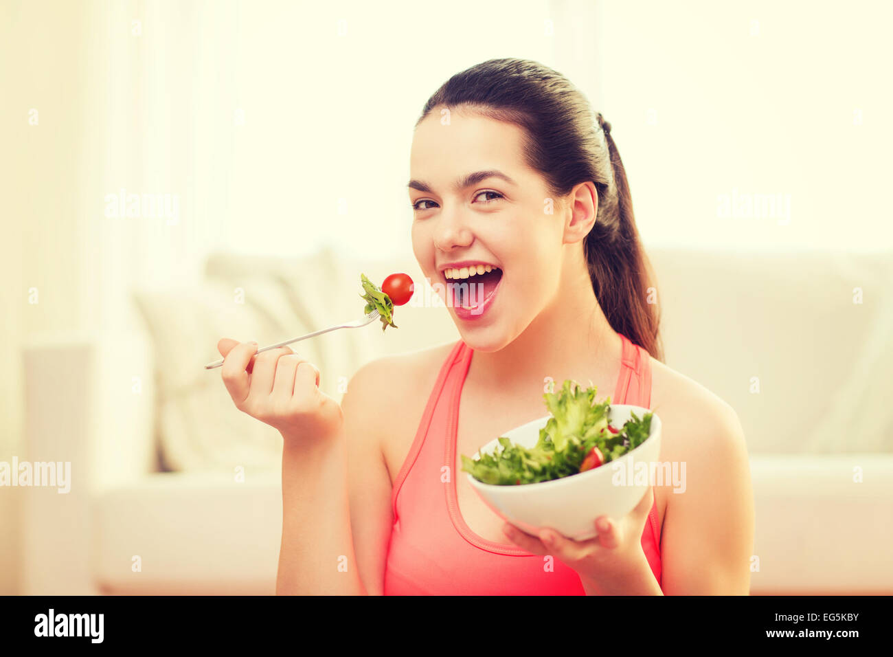smiling teenage girl with green salad at home Stock Photo - Alamy