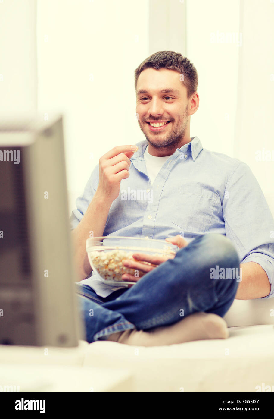 smiling man watching sports at home Stock Photo - Alamy
