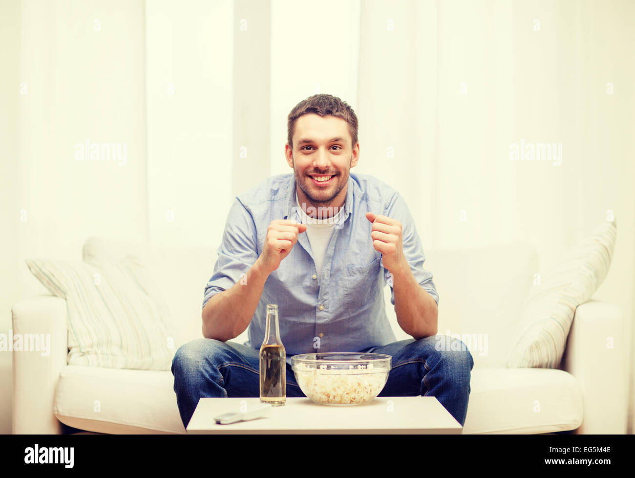 smiling man watching sports at home Stock Photo - Alamy