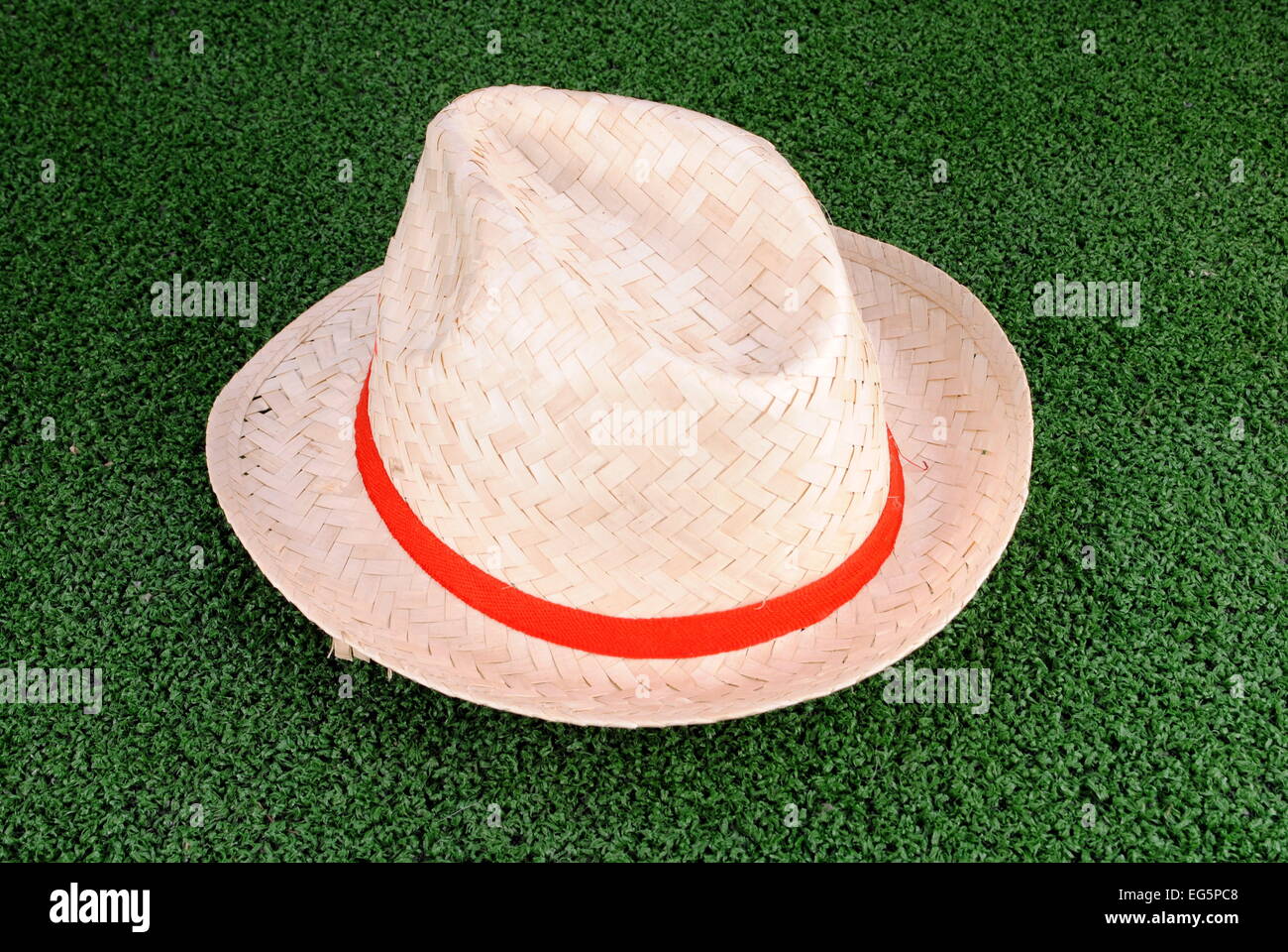 hat made of straw on a green grass background Stock Photo - Alamy