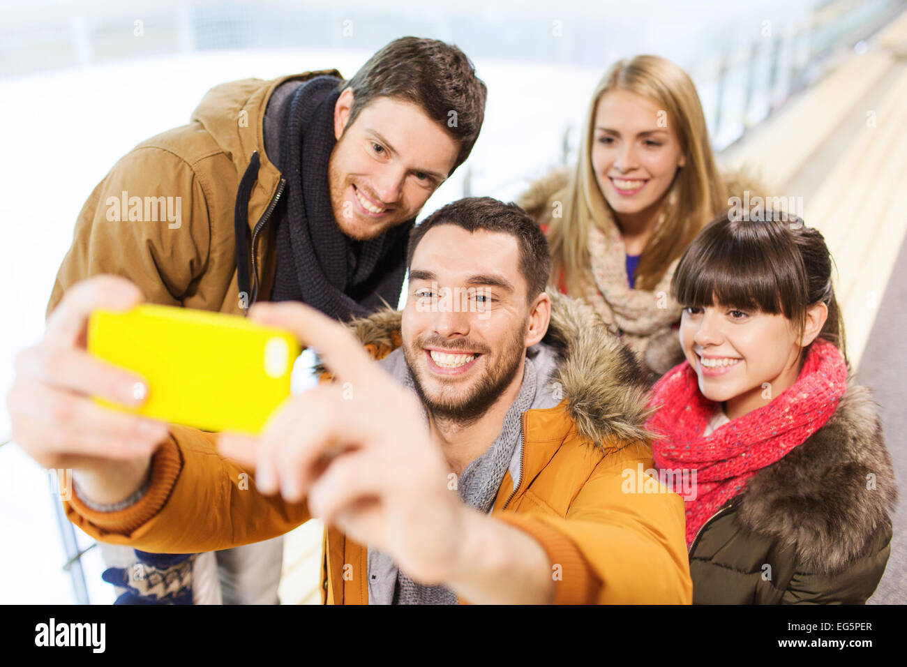 happy friends with smartphone on skating rink Stock Photo - Alamy