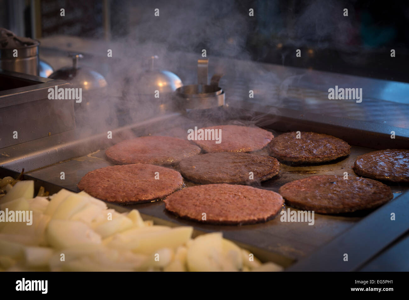 Beefburgers frying on a griddle Stock Photo - Alamy