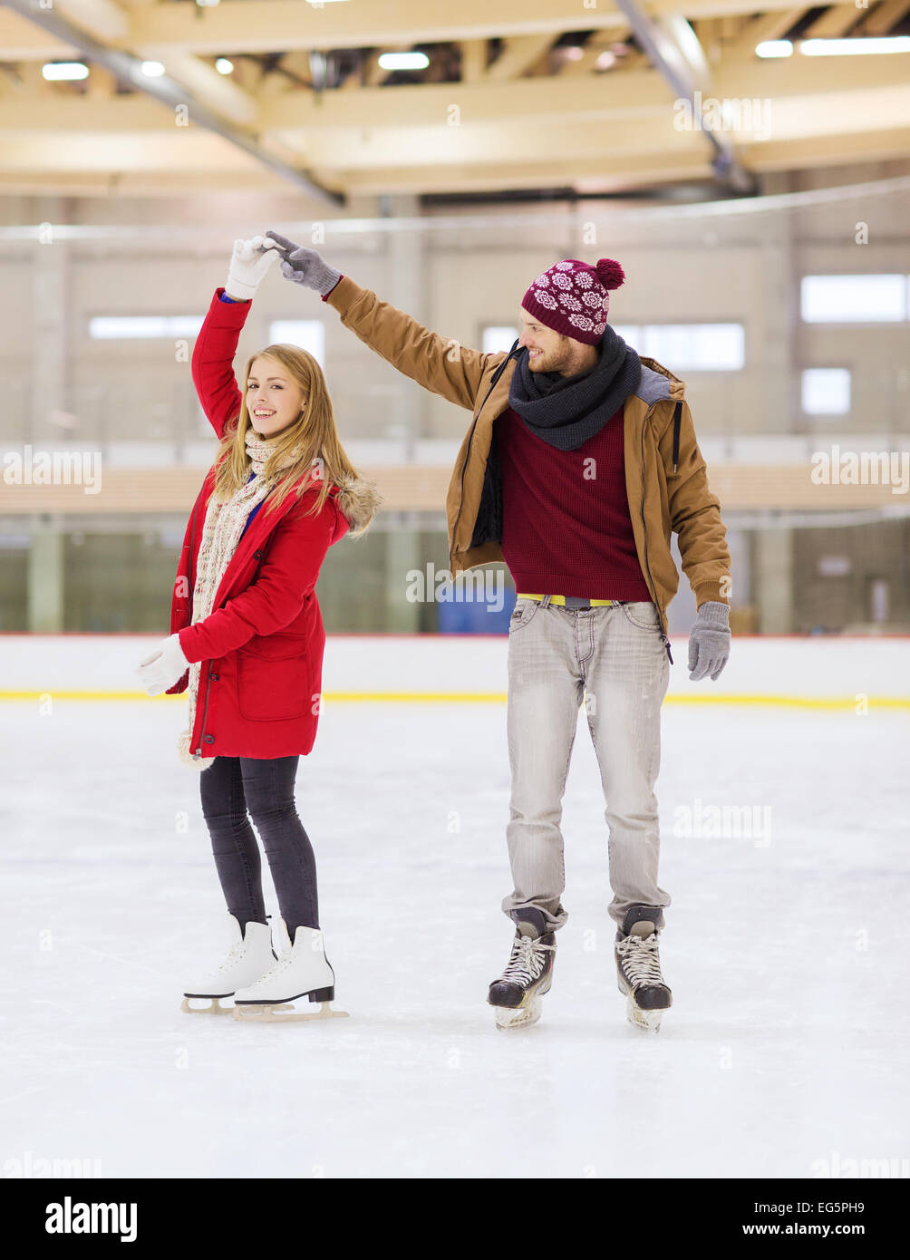 happy couple holding hands on skating rink Stock Photo - Alamy