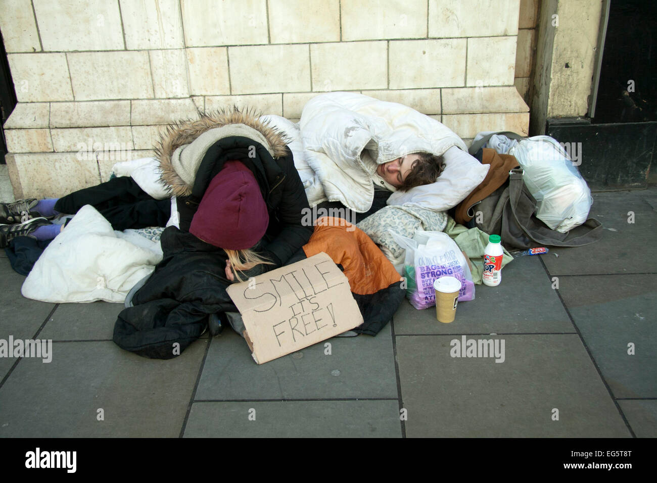 London,UK. 17th February 2015. Pedestrians walk past homeless people ...
