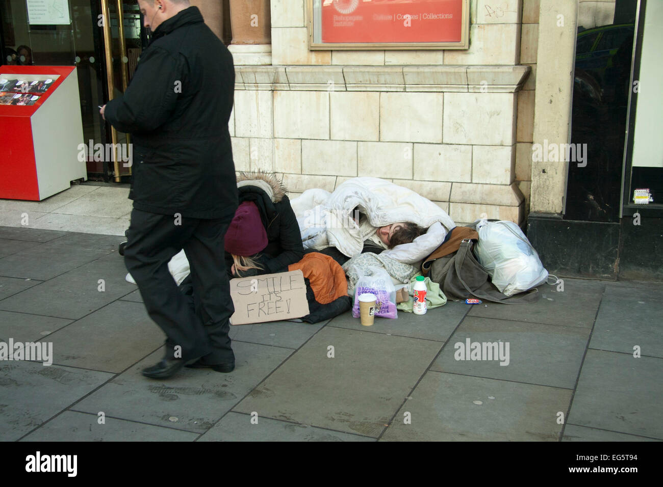London,UK. 17th February 2015. Pedestrians walk past homeless people ...