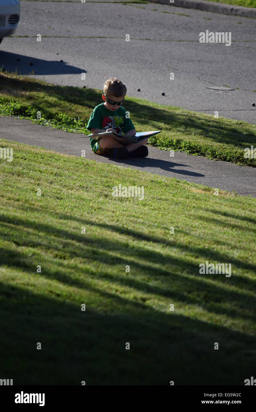 Child reading outside hi-res stock photography and images - Alamy
