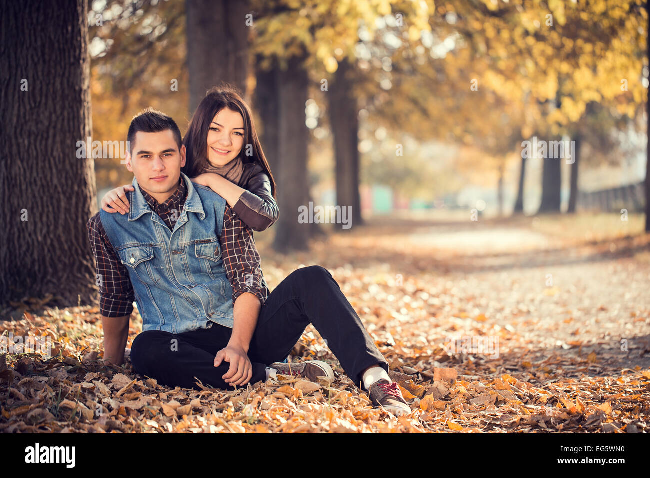 couple autumn park sitting hugging Stock Photo - Alamy
