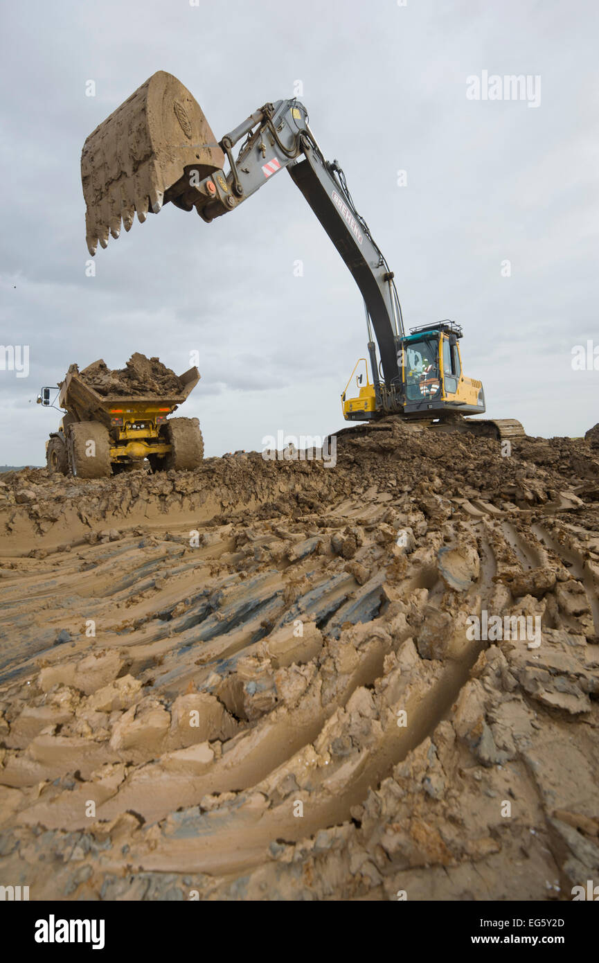 Heavy earth excavator removes clay for future replacement with topsoil ...