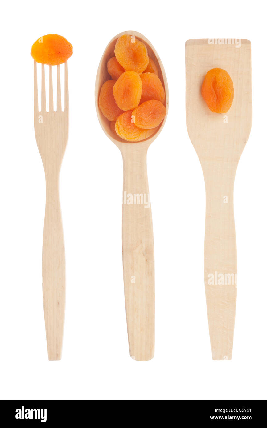 Wooden spoon, fork, paddle with dried apricots isolated on white ...