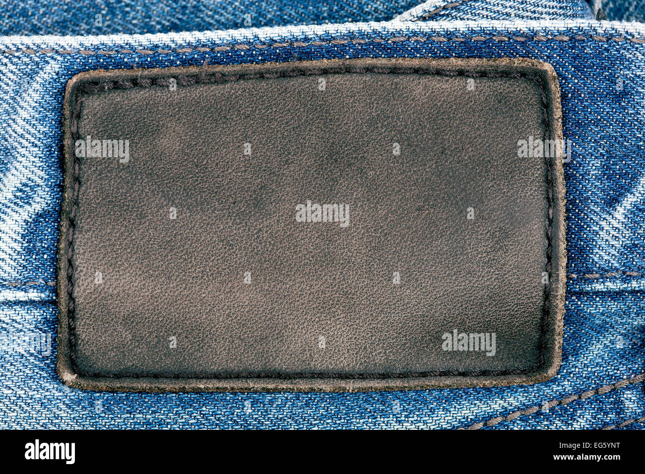 Blank leather jeans label sewed on a blue jeans Stock Photo - Alamy
