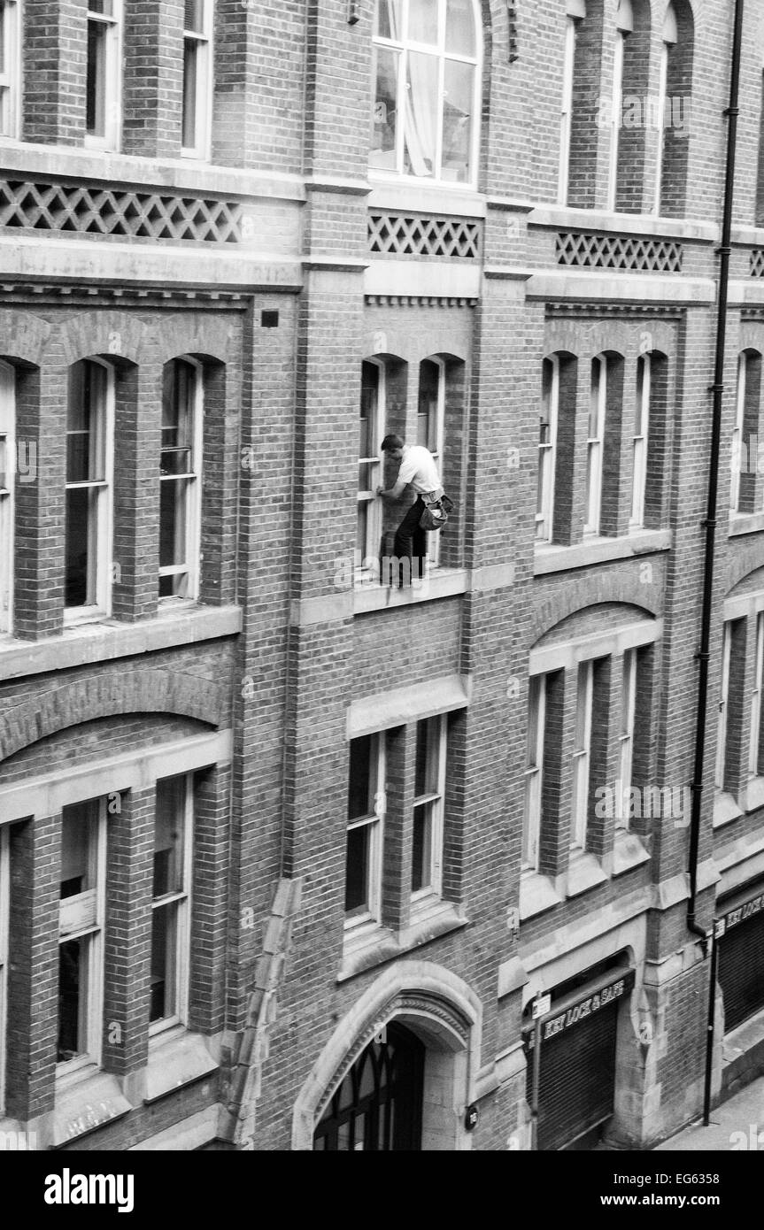 Man climbing out of window hi-res stock photography and images - Alamy