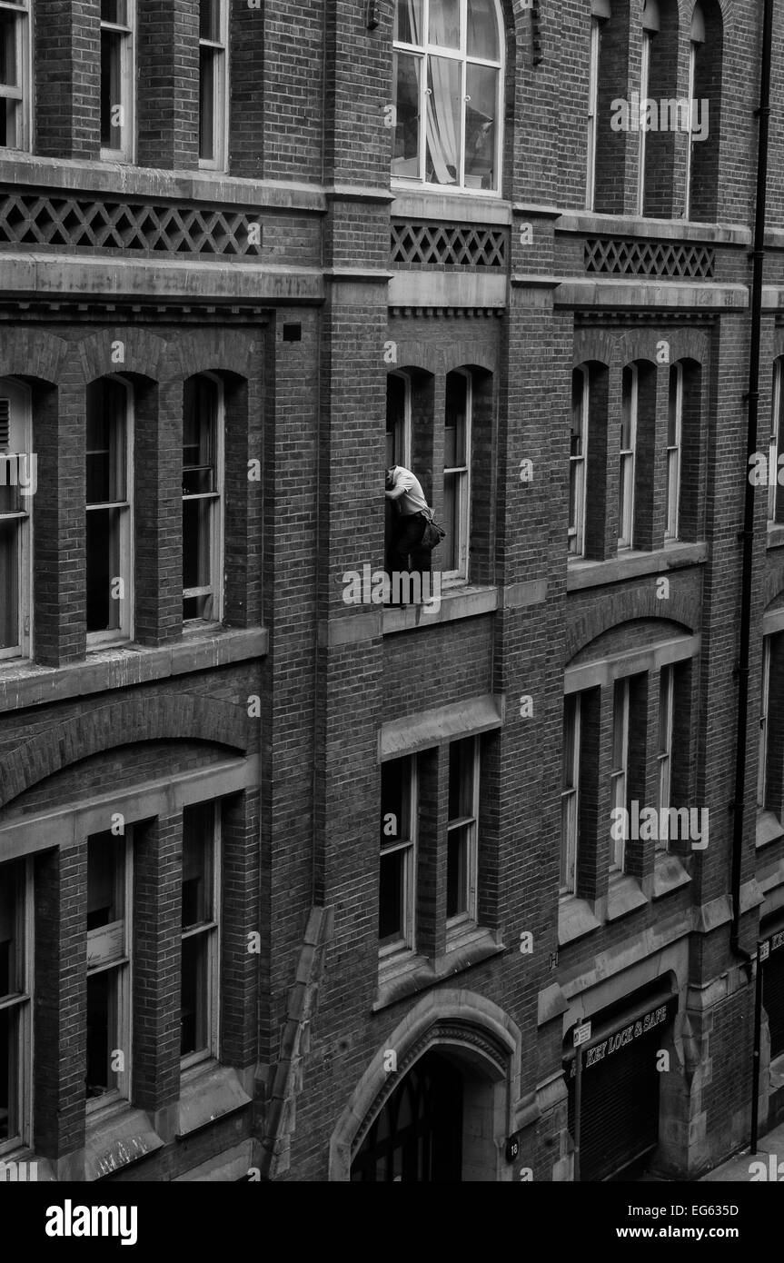Man climbing out of window hi-res stock photography and images - Alamy