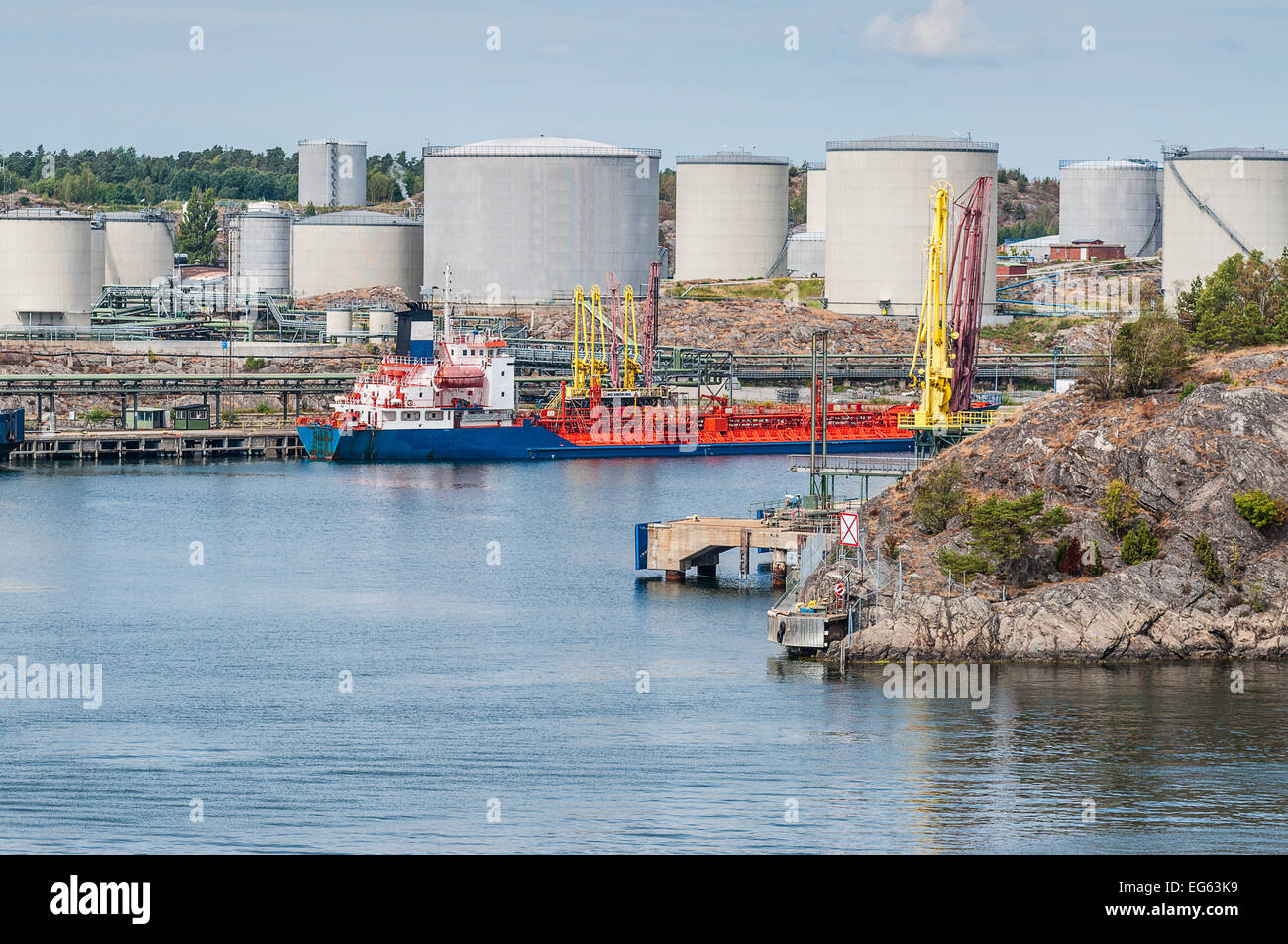 Tanker unloading with oil storage tanks in the background Stock Photo ...