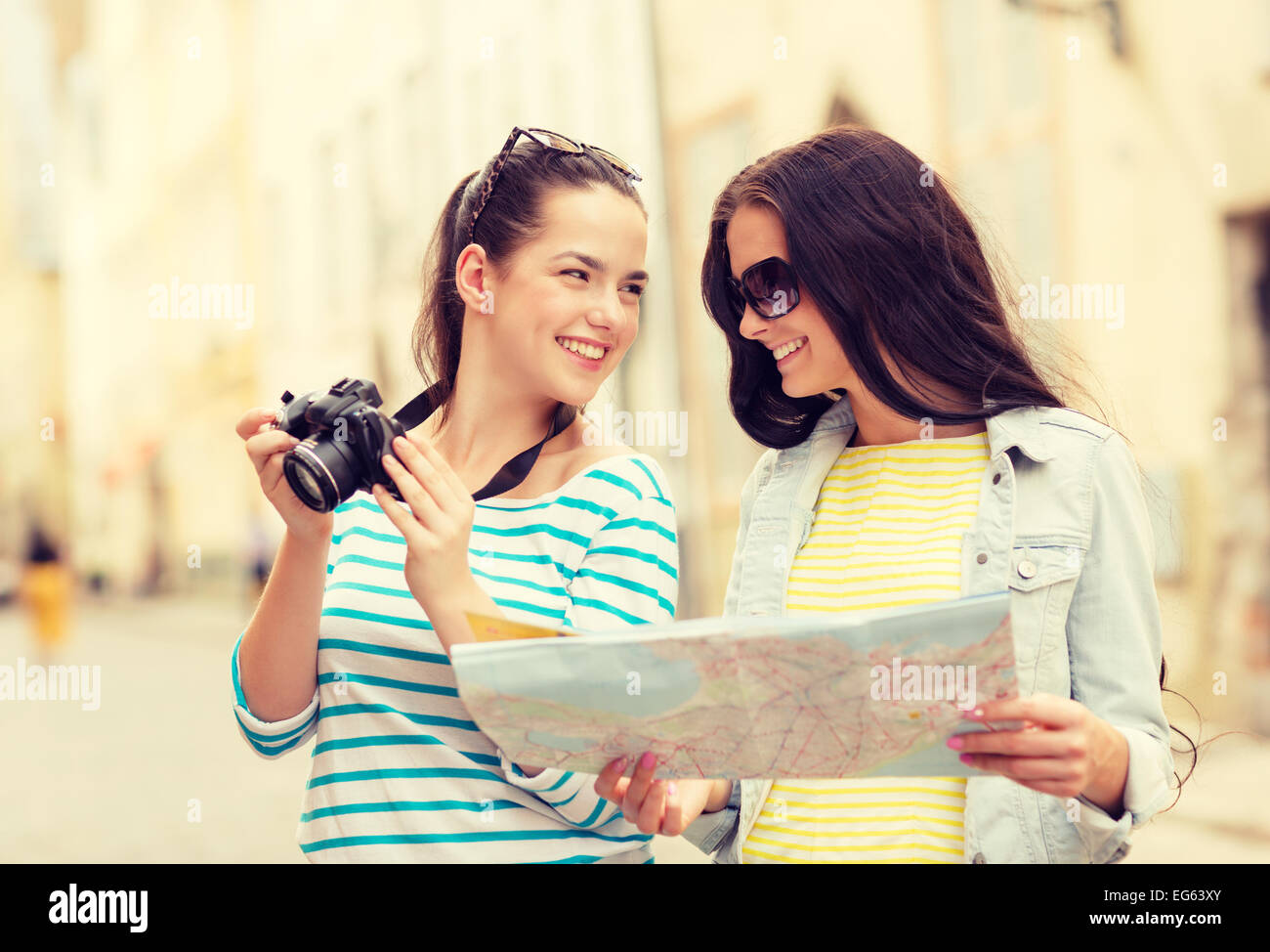 smiling teenage girls with map Stock Photo - Alamy