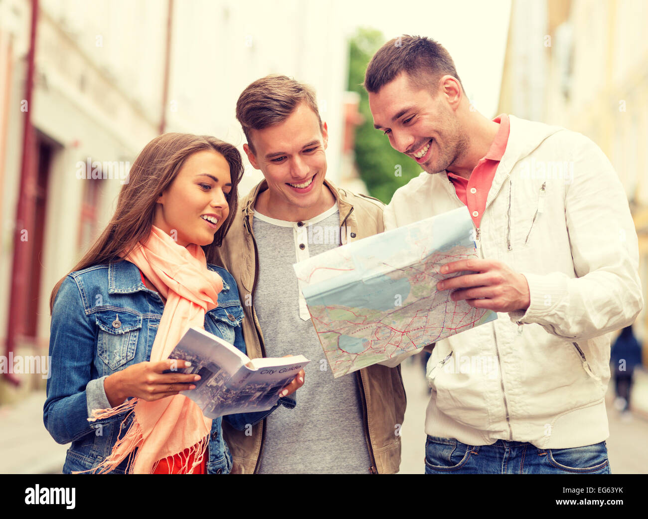 group of smiling friends with city guide and map Stock Photo - Alamy
