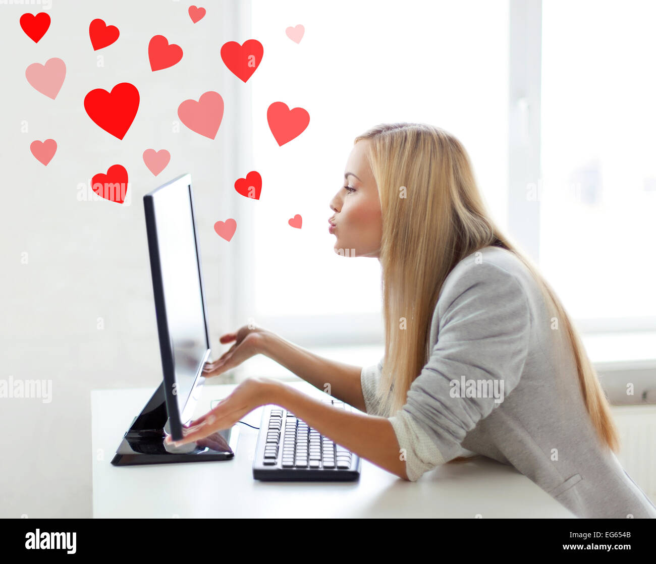 woman sending kisses with computer monitor Stock Photo - Alamy