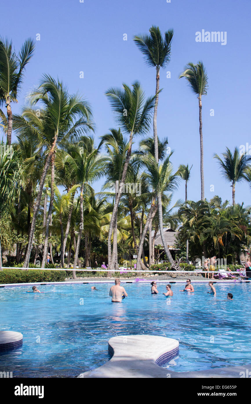 A group of random people playing volleyball in a swimming pool at a ...