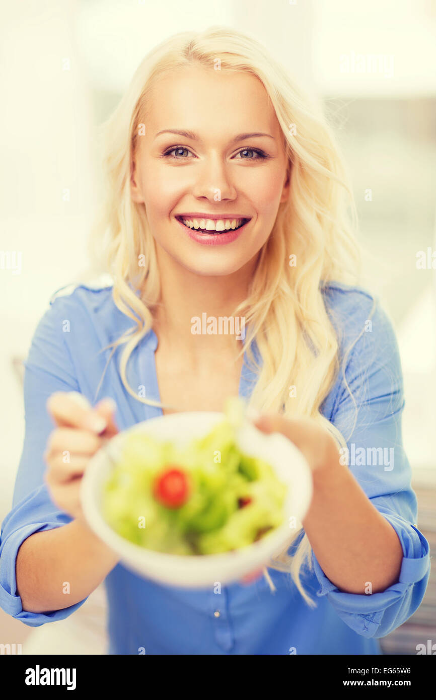 smiling young woman with green salad at home Stock Photo - Alamy