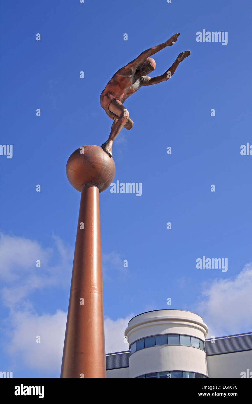 Bronze seafront sculpture of a person diving under blue sky and ...