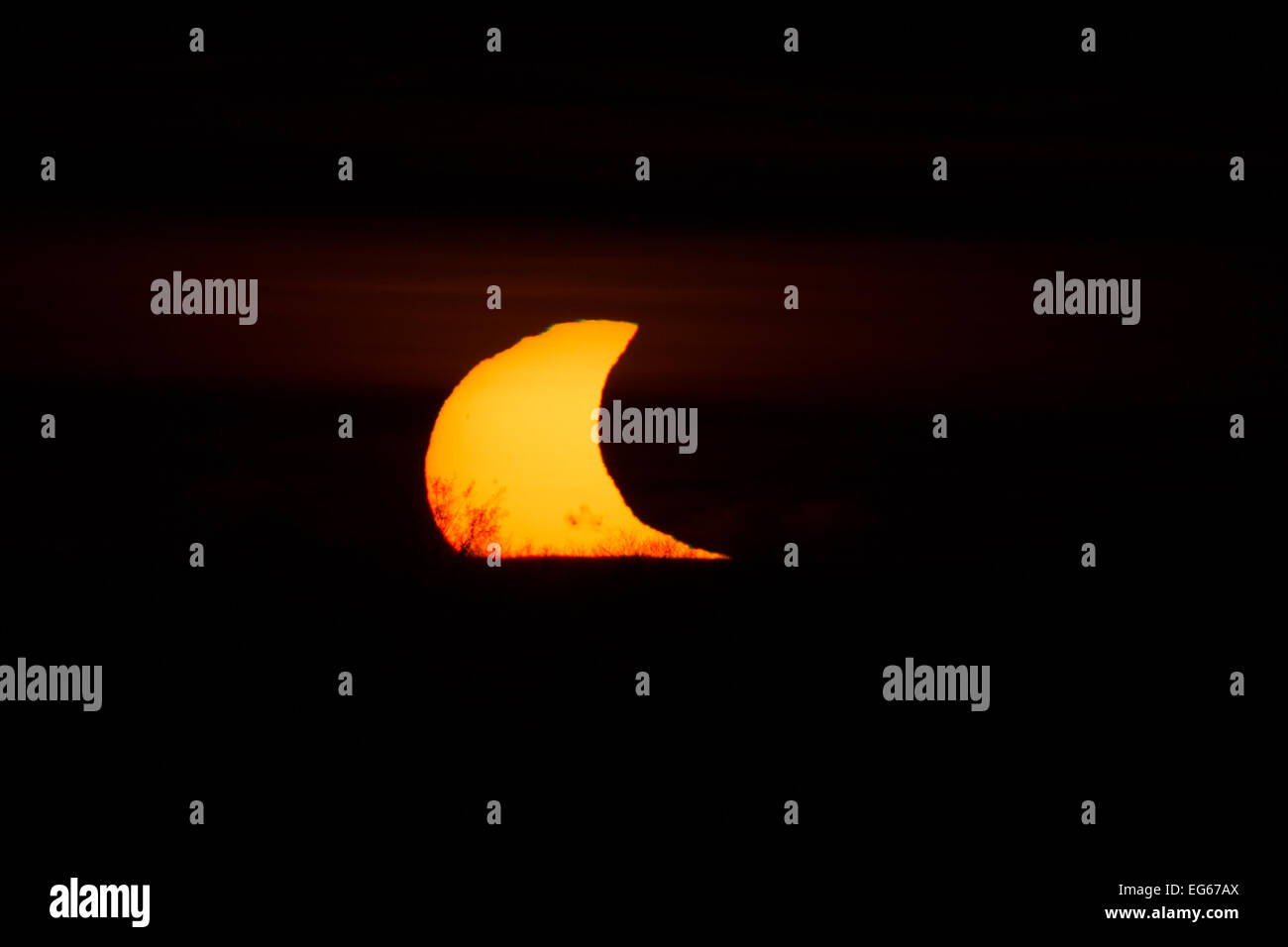 Sunset with a partial solar eclipse visible as the moon blocks out the ...