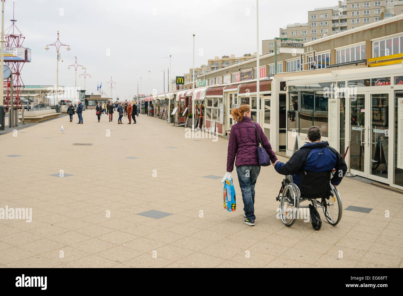 People walk along the promenade at Scheveningen Strand during a cold ...