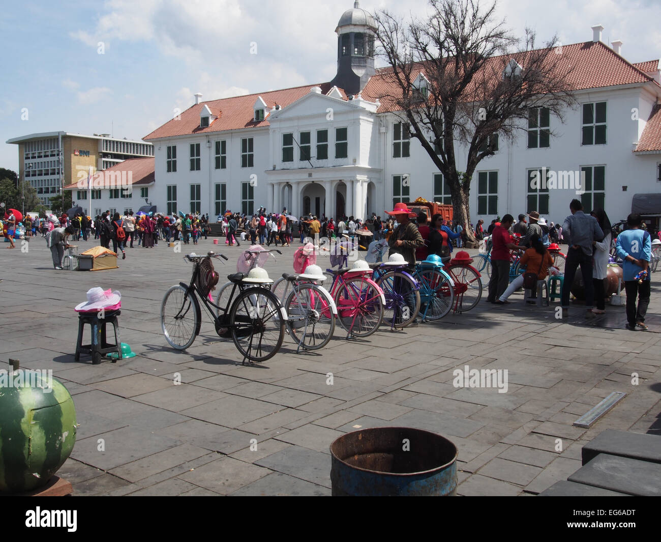 A crowd of young people taking a rest on the sunny square in front of ...