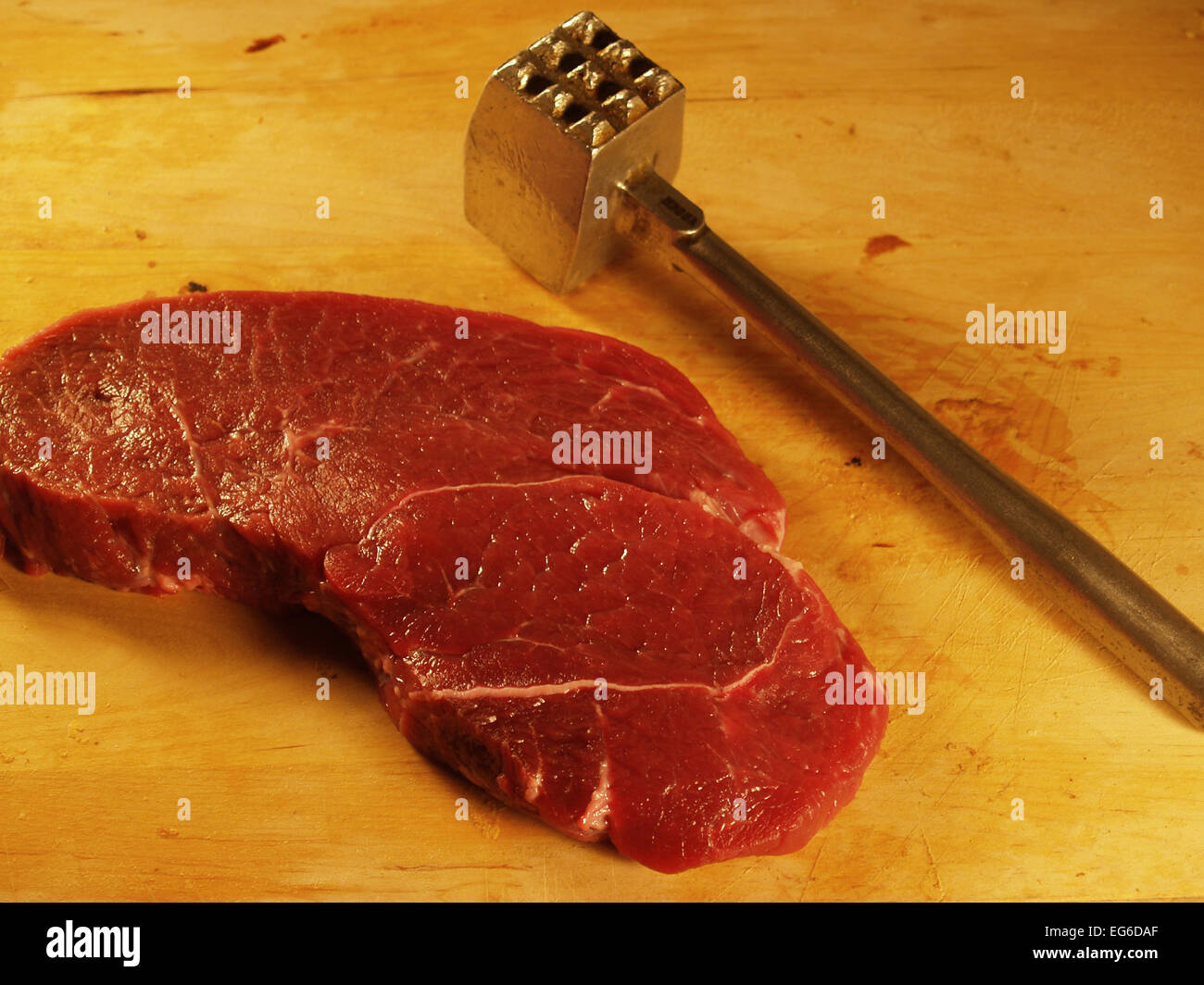 Raw meat and the hammer on wooden board Stock Photo - Alamy