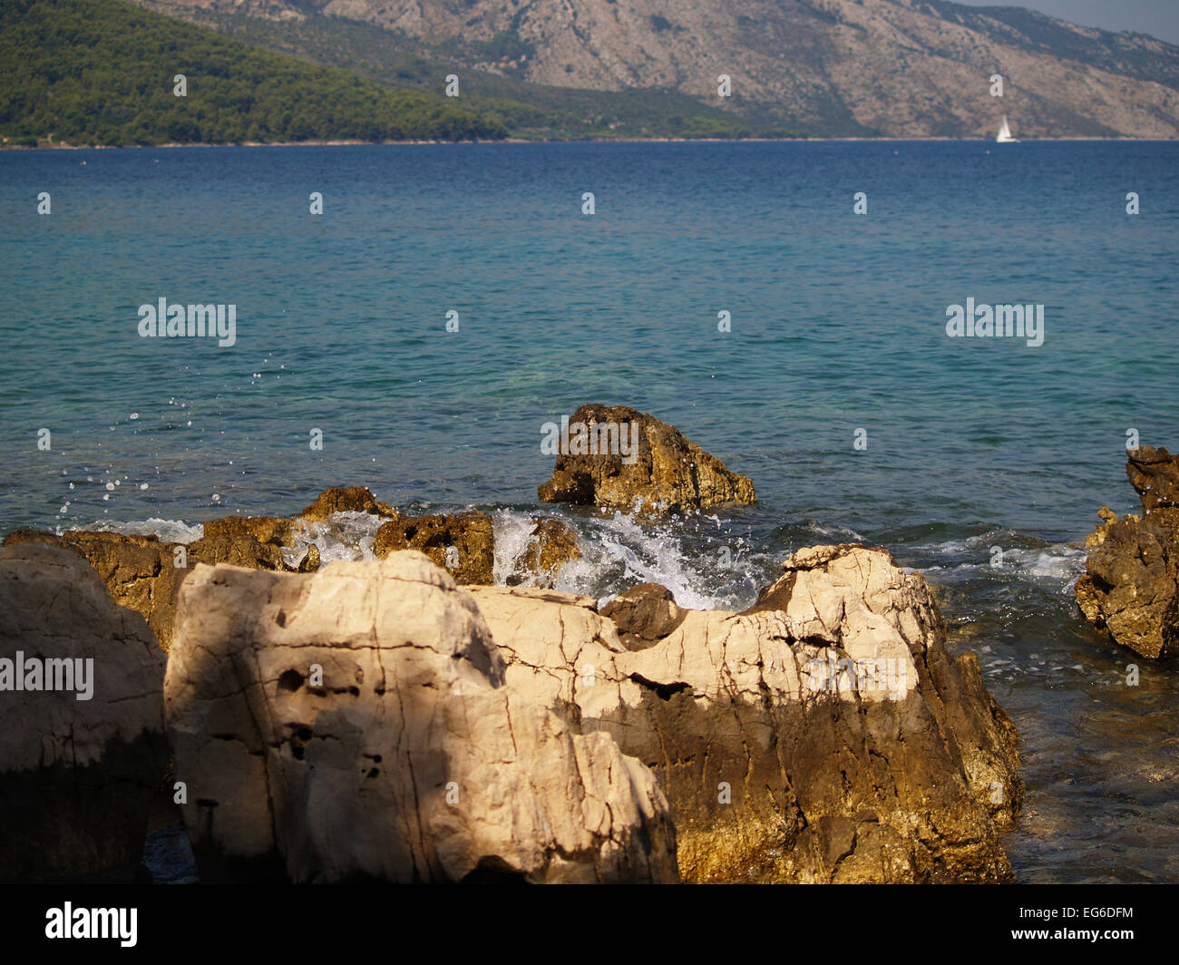 Rock in blue waves against sea coast Stock Photo - Alamy
