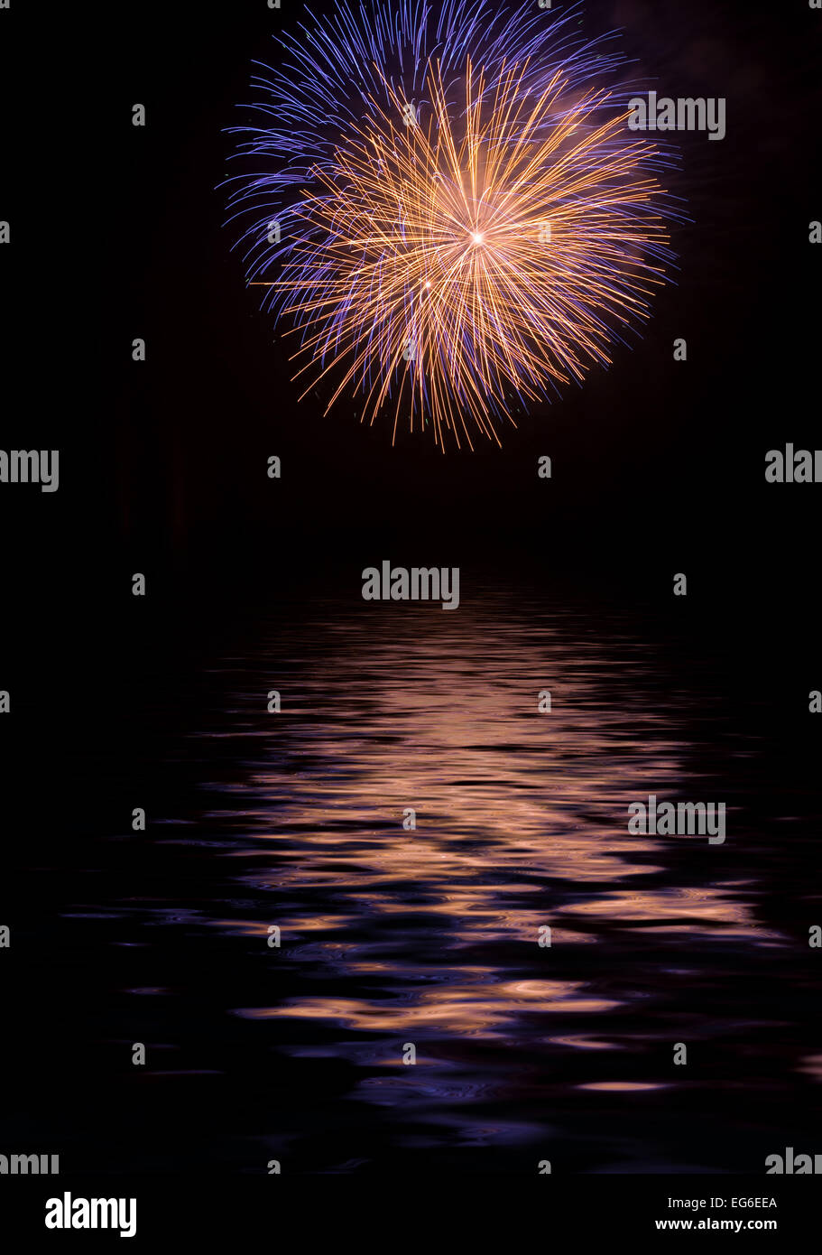 Exploding fireworks with reflexes on water at night Stock Photo - Alamy