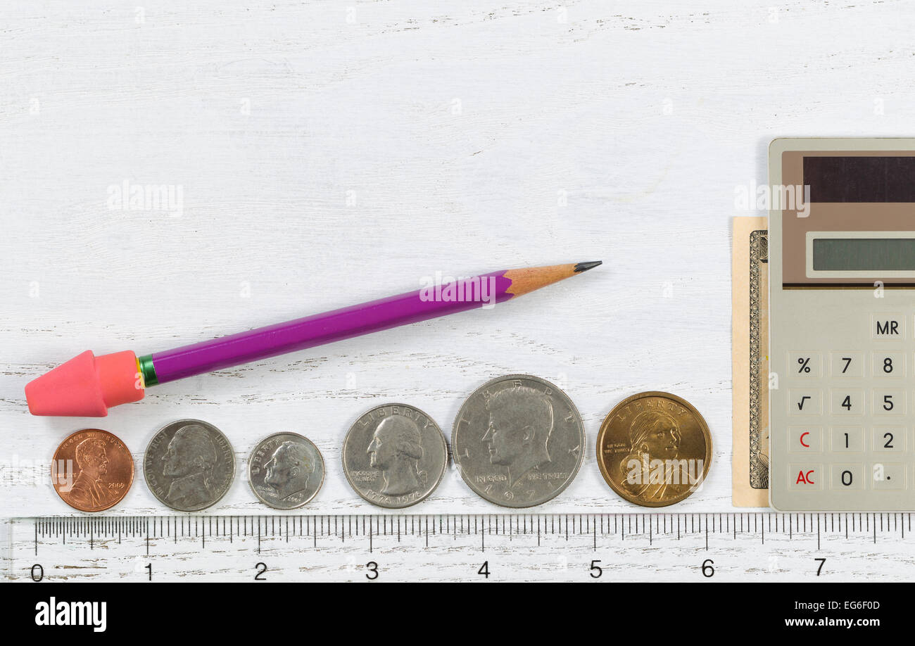 Clear plastic ruler with coins and money reflecting the concept of ...