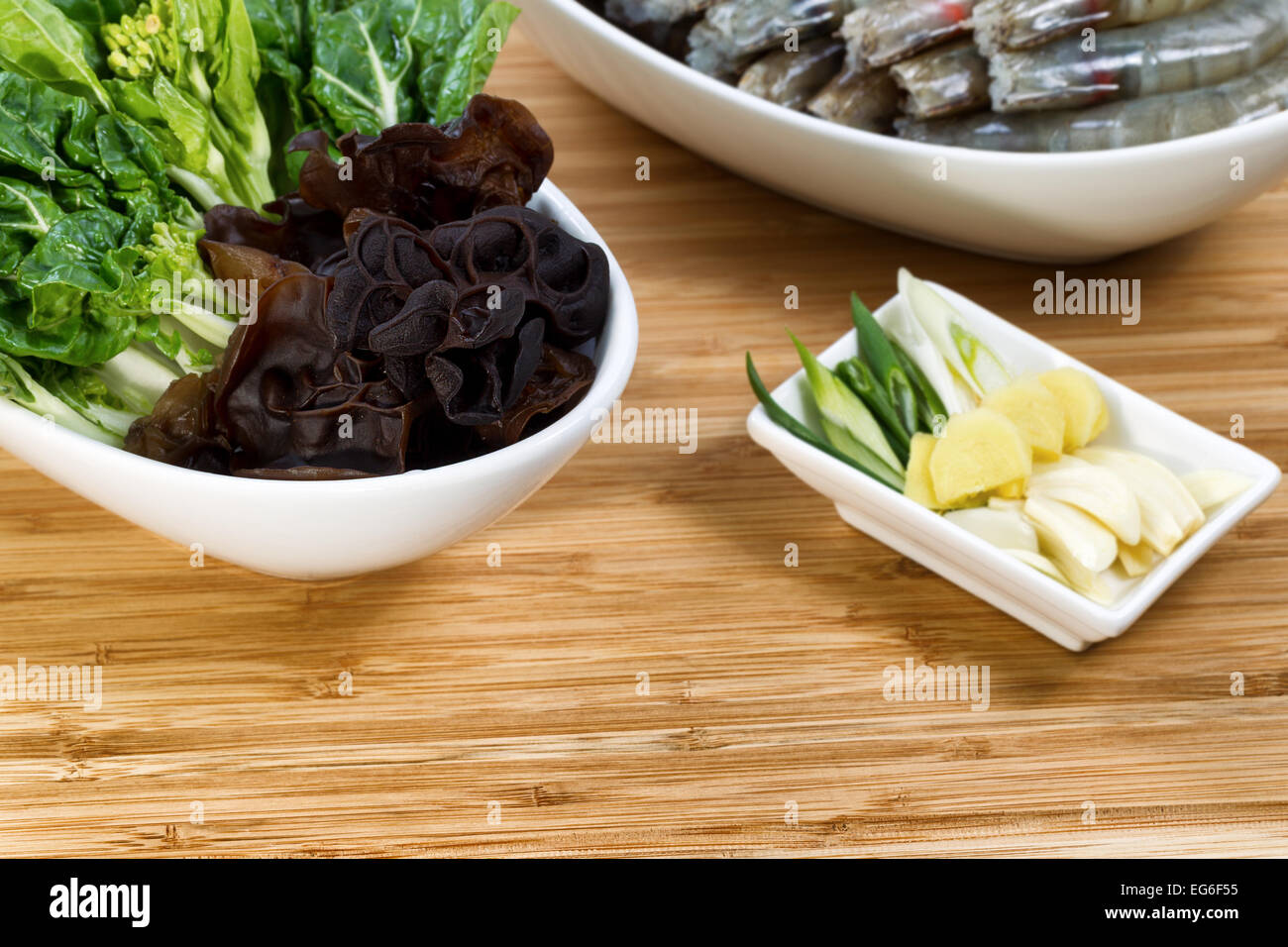 Close up front view of raw vegetables, focus on front of large bowl on ...