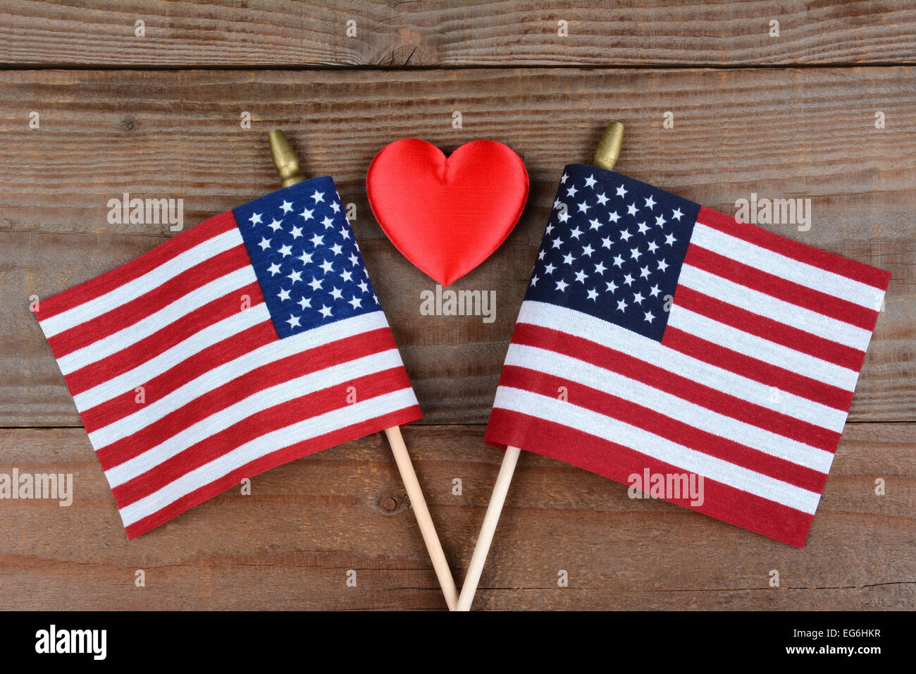 High angle shot of two crossed American flags on a rustic wood surface ...