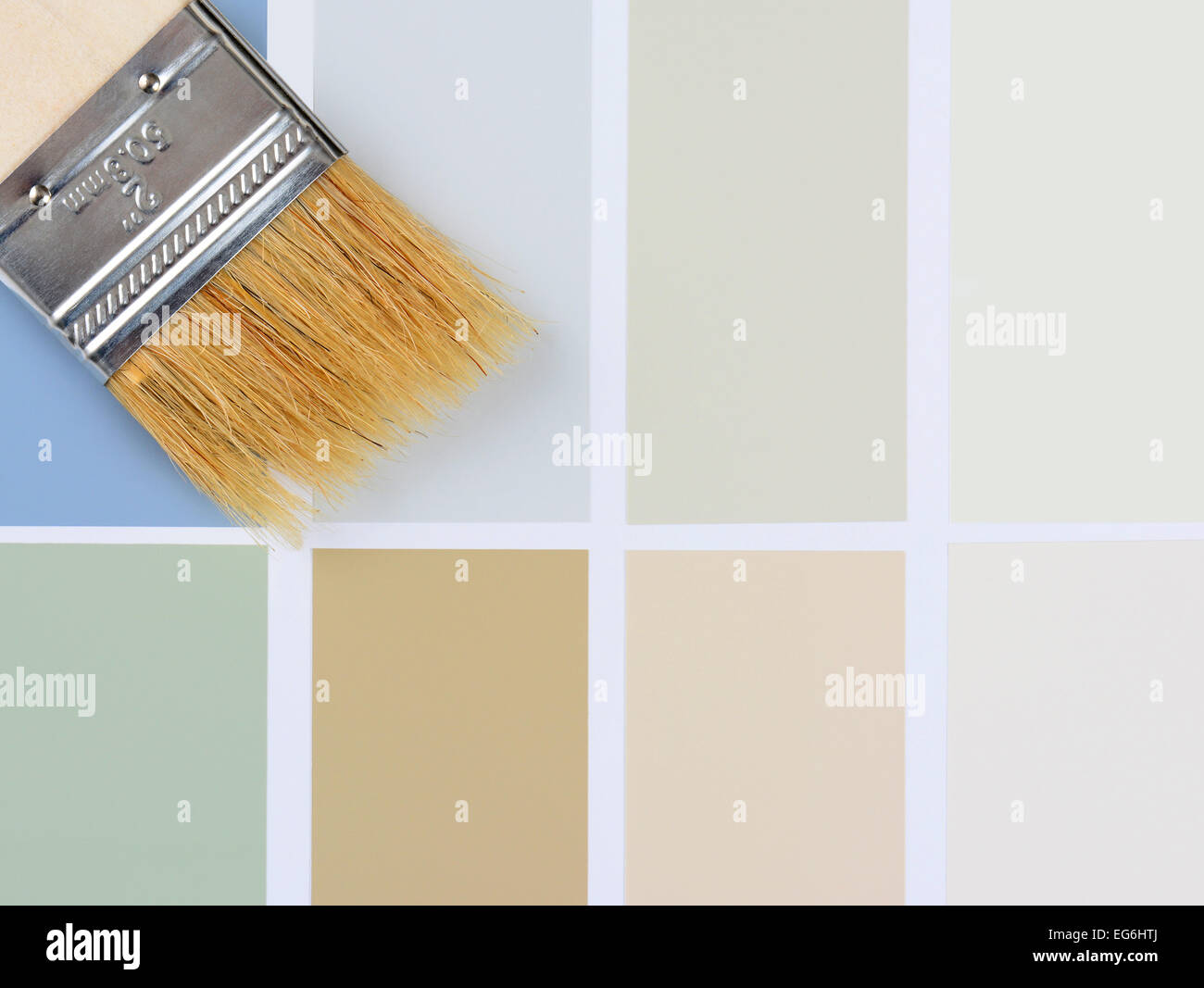 Closeup overhead shot of a paint brush laying on a color sample chart ...