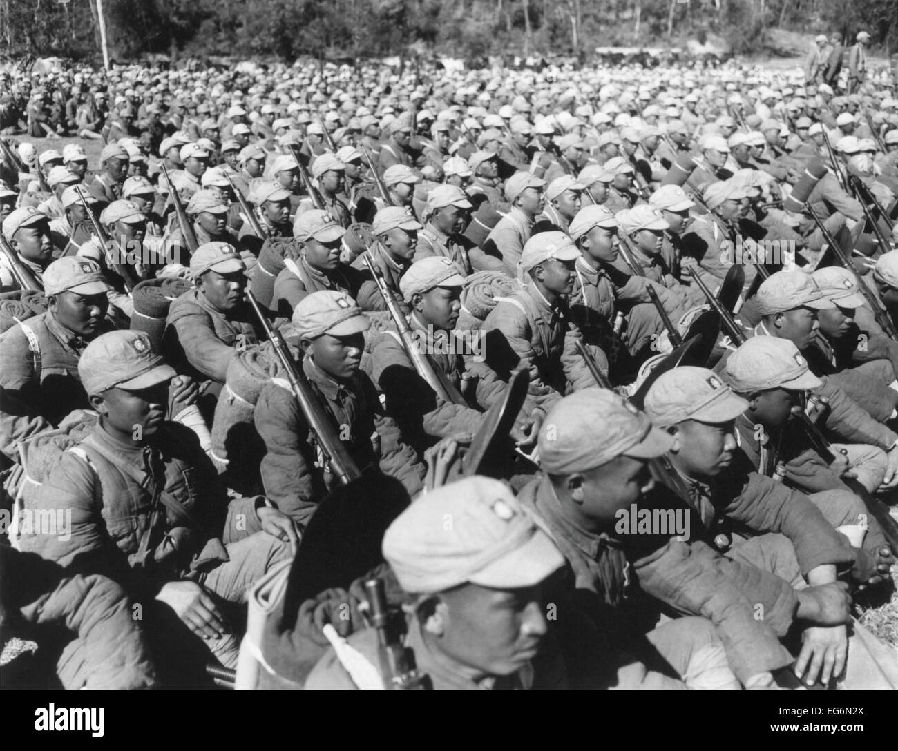 Chinese soldiers seated in rows equipped with rifles and fresh uniforms ...