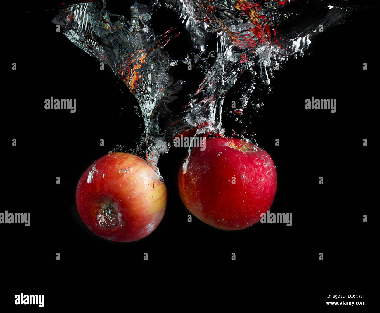Apples are falling into the water with a splash and air bubbles on a ...