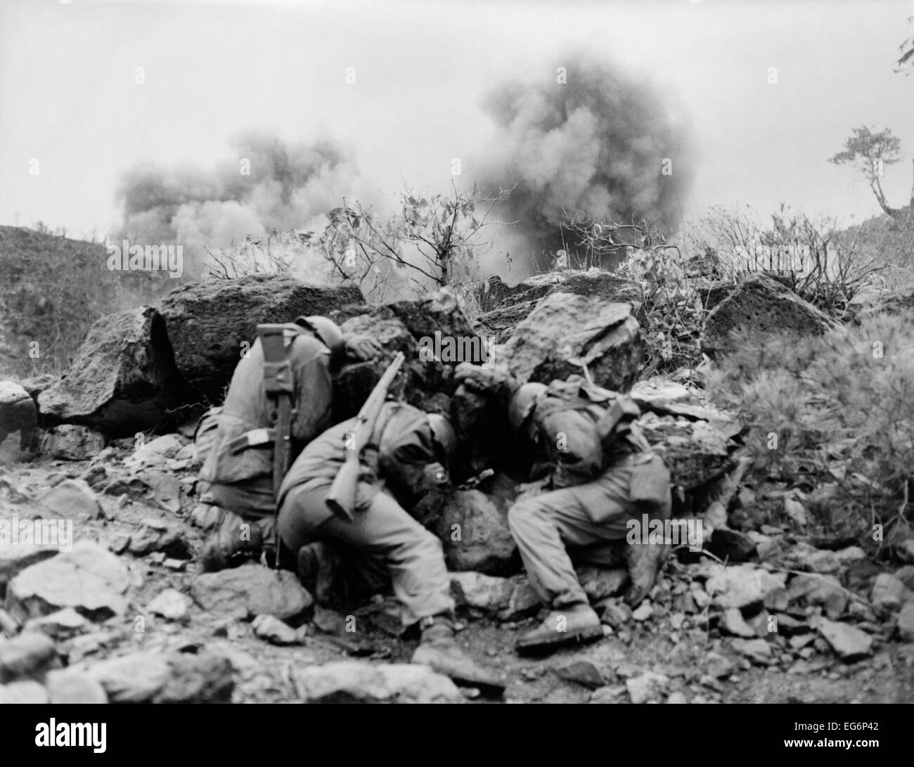 U.S. soldiers behind rocks to shield themselves from exploding mortar ...