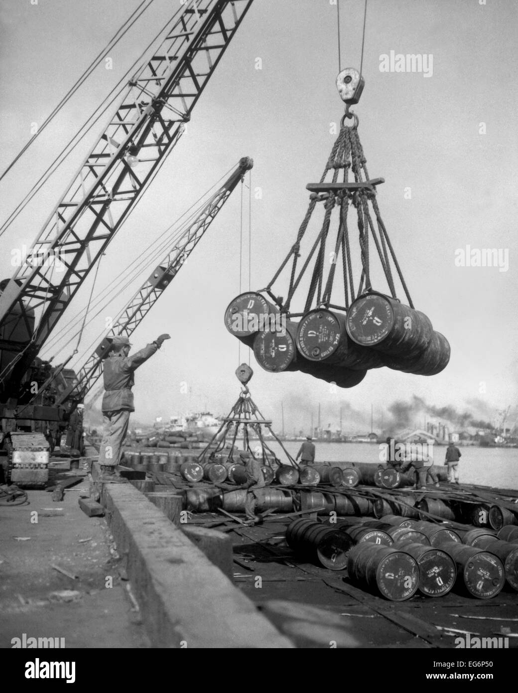 Fuel drums are lifted and moved with cranes from a tanker at Inchon ...