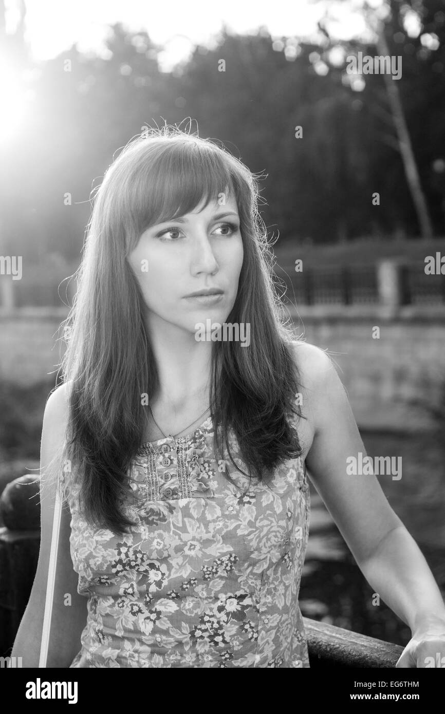 Young caucasian woman posing near river at the town. Black and white ...