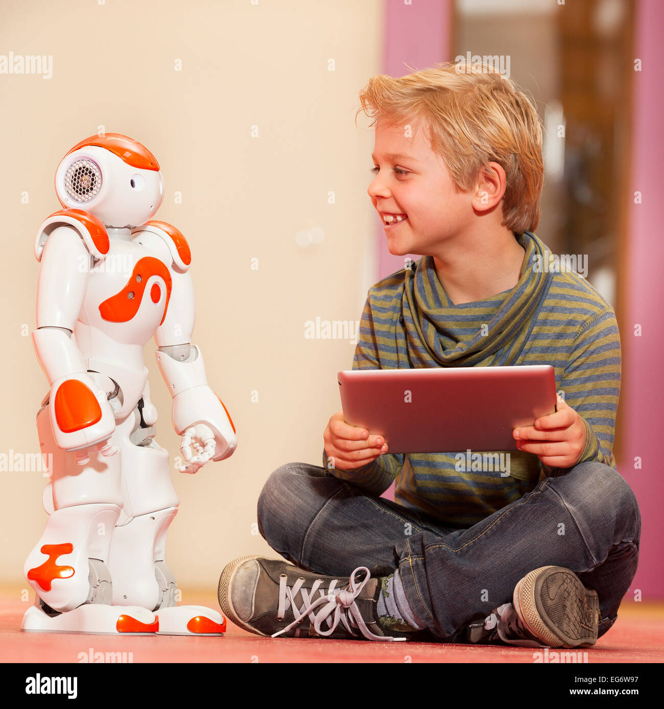 Young child playing with humanoid robot during school time Stock Photo ...