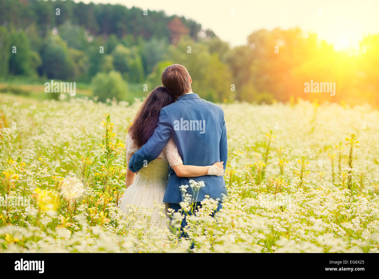 Young happy wedding couple hugging in the meadow back to camera Stock ...
