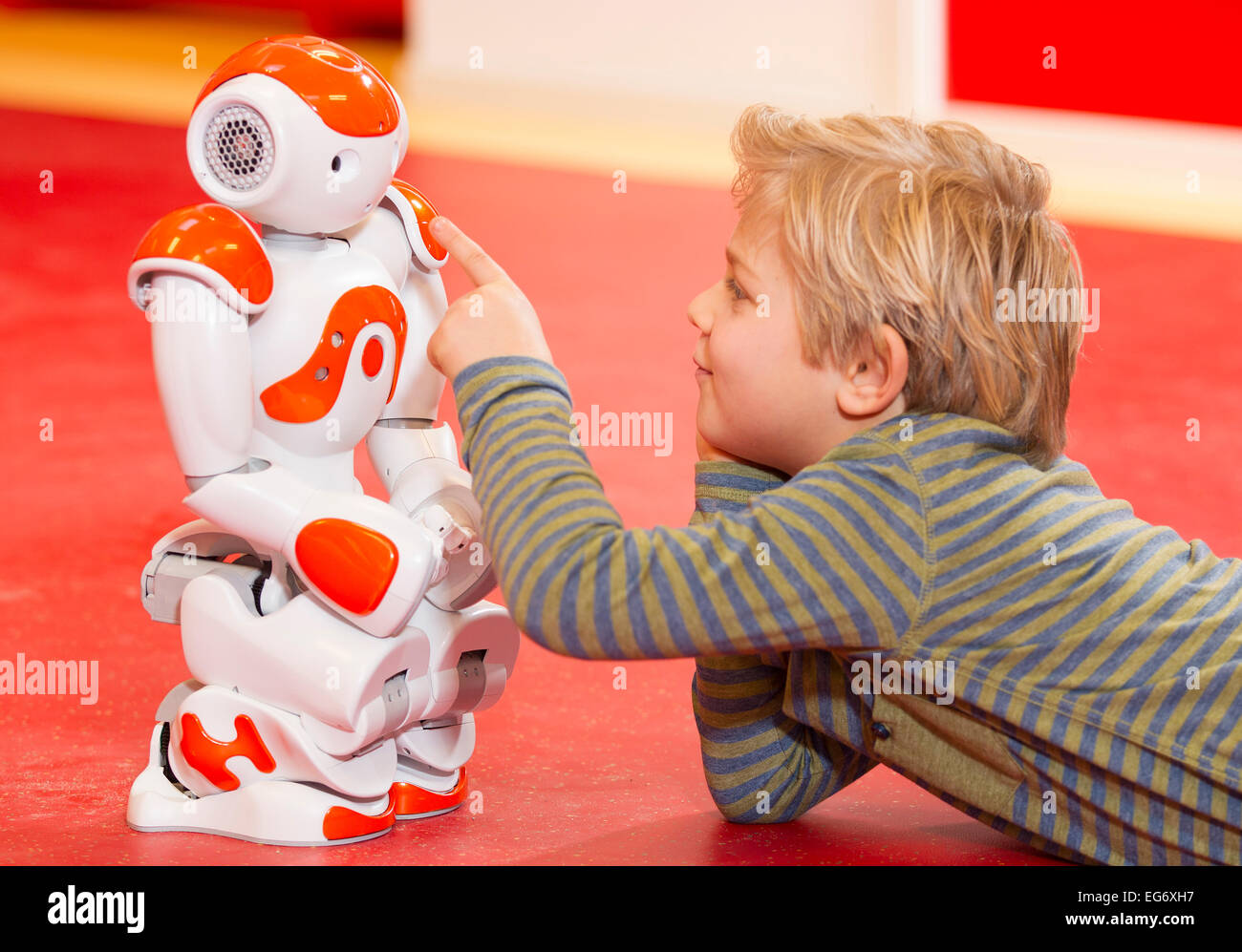 Young child playing with humanoid robot during school time Stock Photo ...