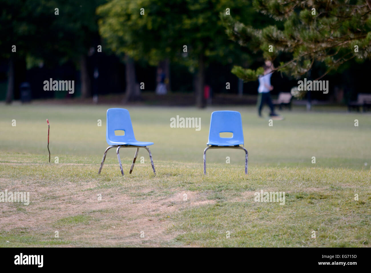 Two small blue plastic seats on putting golf course Stock Photo - Alamy