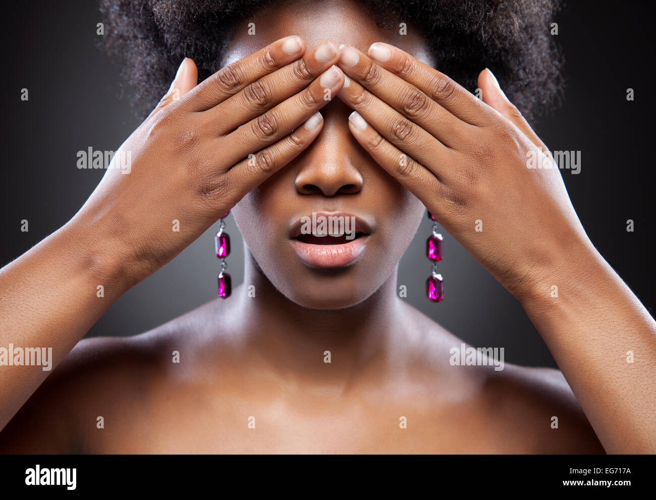 Black beauty covering eyes with both of her hands Stock Photo - Alamy