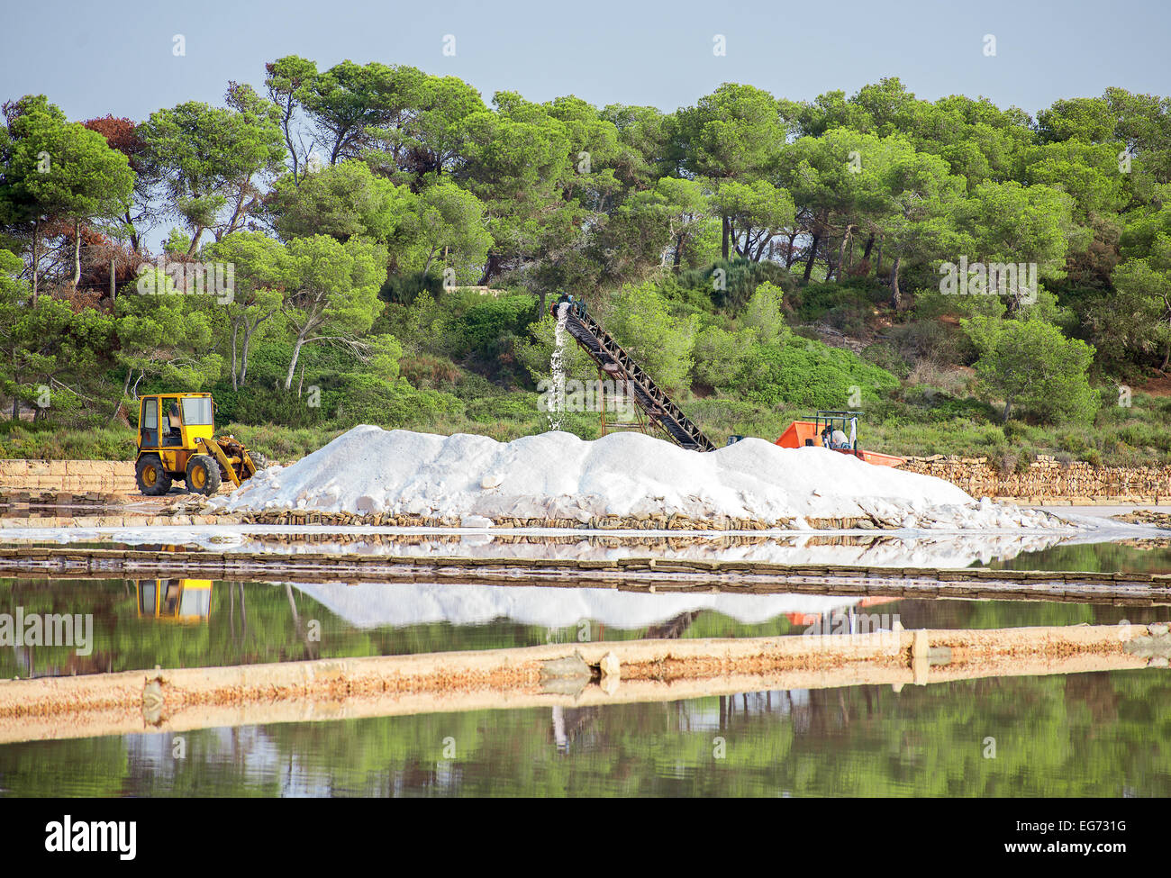 Sea salt production. Salt evaporation pond with tractor and conveyor ...